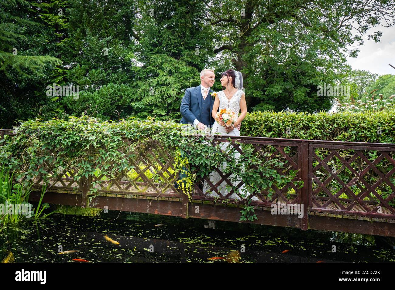 Bride and Groom pose for their after ceremony pictures in the gardens ...