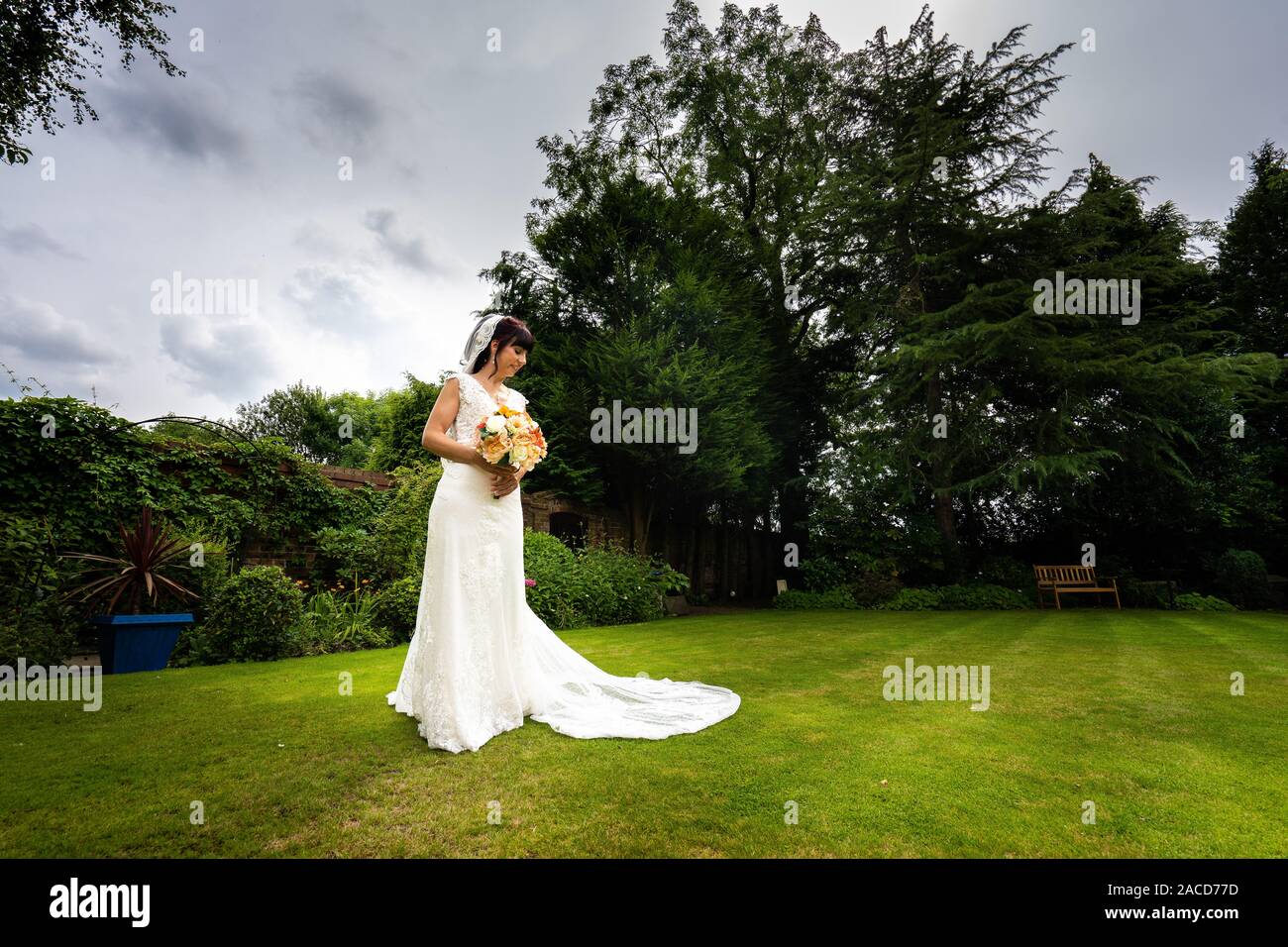 A bride poses for her after ceremony pictures in the gardens at the ...
