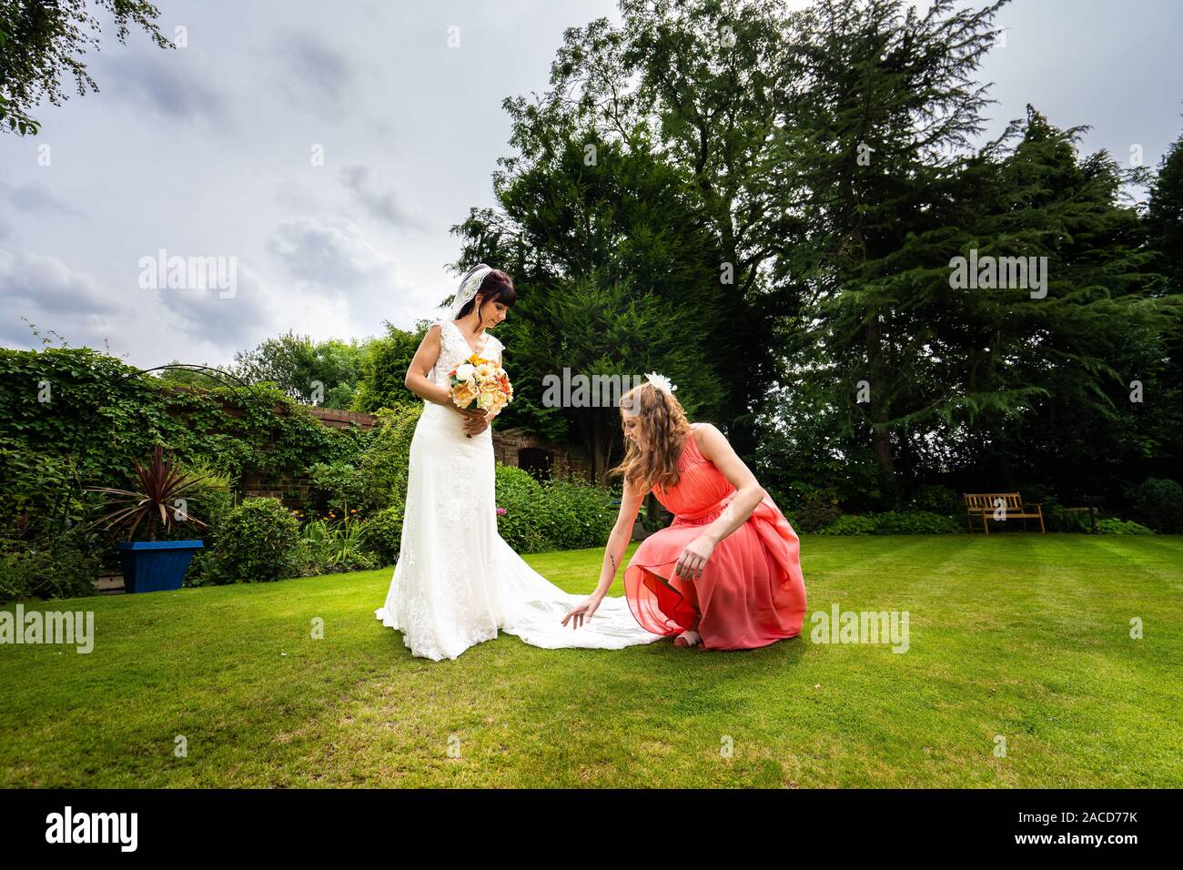 A bride and her maid of honour smiling, laughing and having fun on a ...