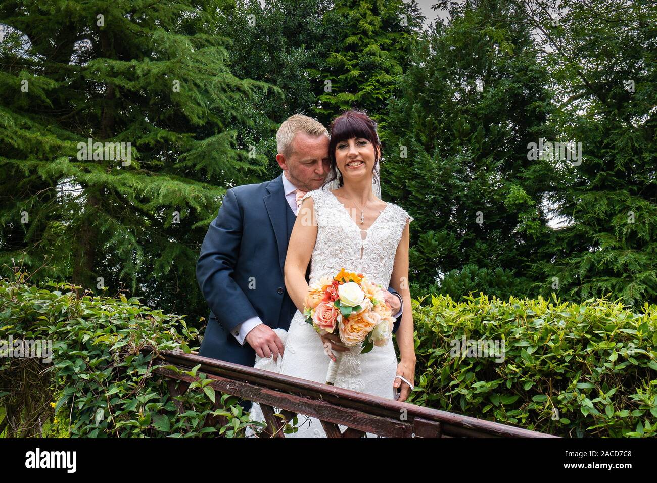 Bride and Groom pose for their after ceremony pictures in the gardens ...