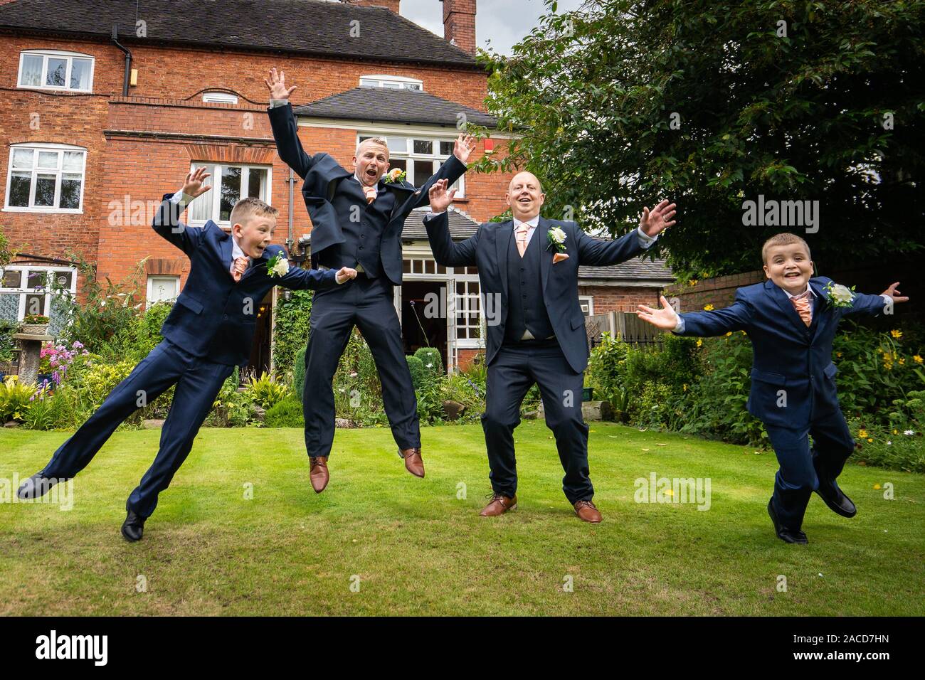 Bride, Groom and wedding guests pose for picture outside at the Manor ...