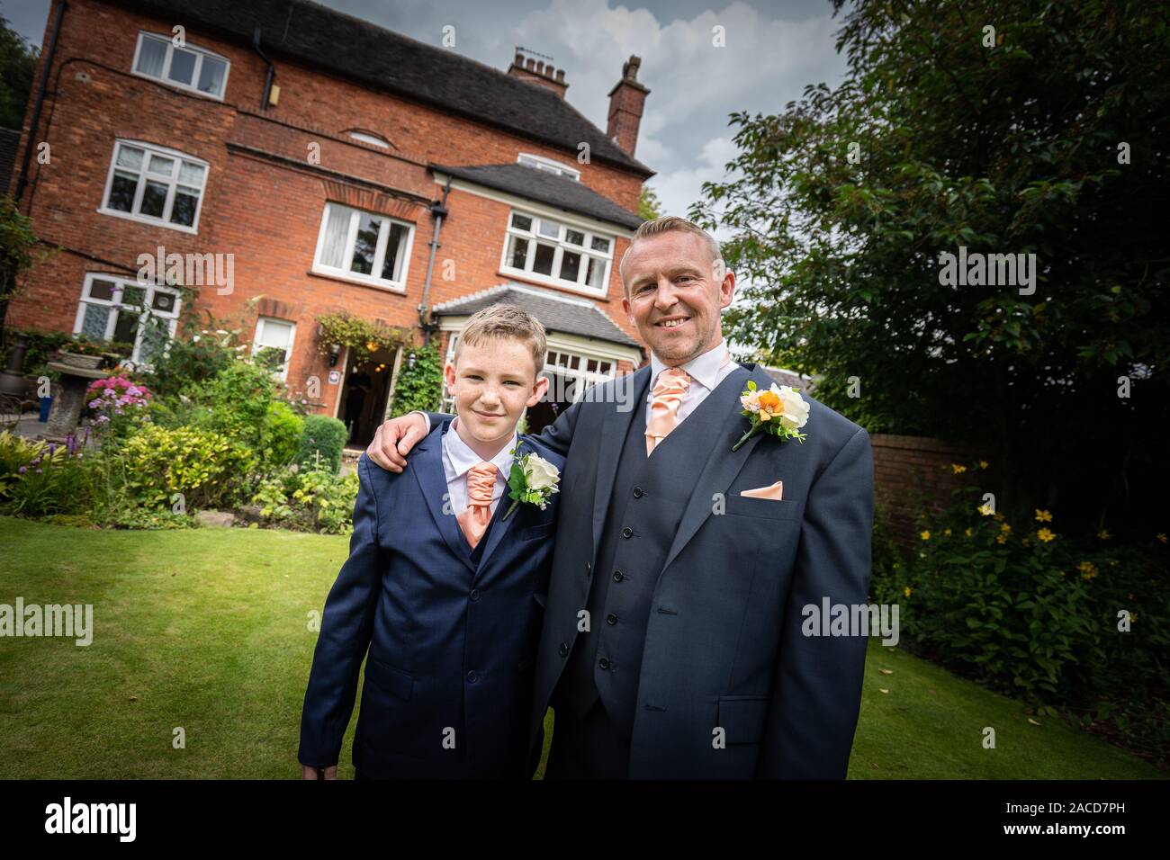 Bride, Groom and wedding guests pose for picture outside at the Manor ...