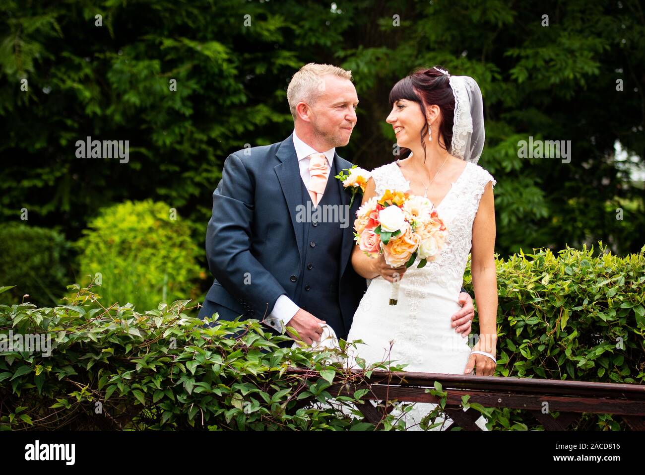 A bride and groom smiling, laughing together happy and in love on their ...