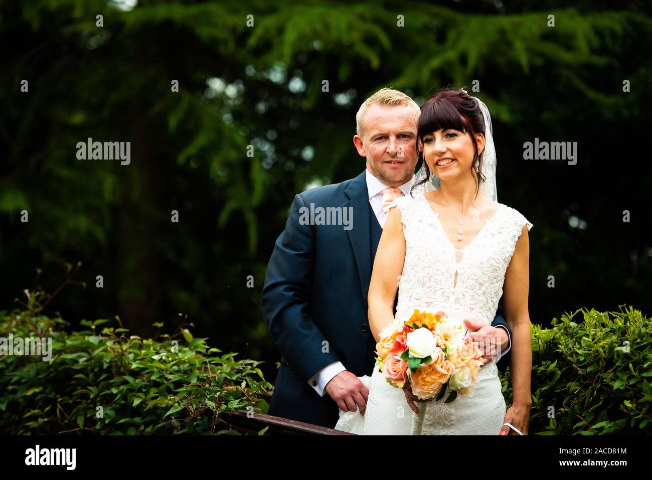 Bride and Groom pose for their after ceremony pictures in the gardens ...