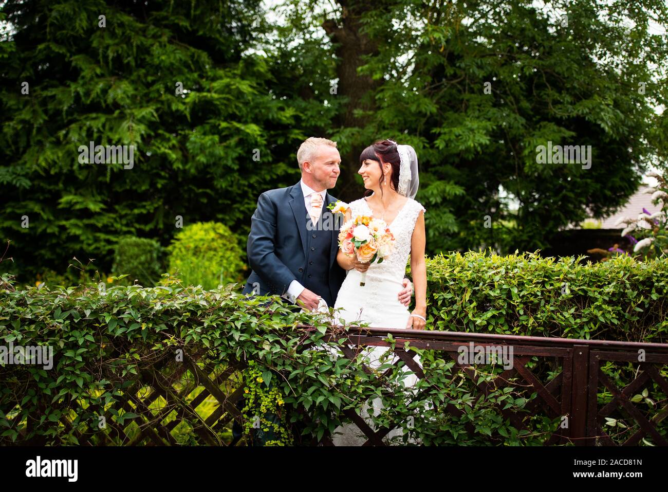Bride and Groom pose for their after ceremony pictures in the gardens ...