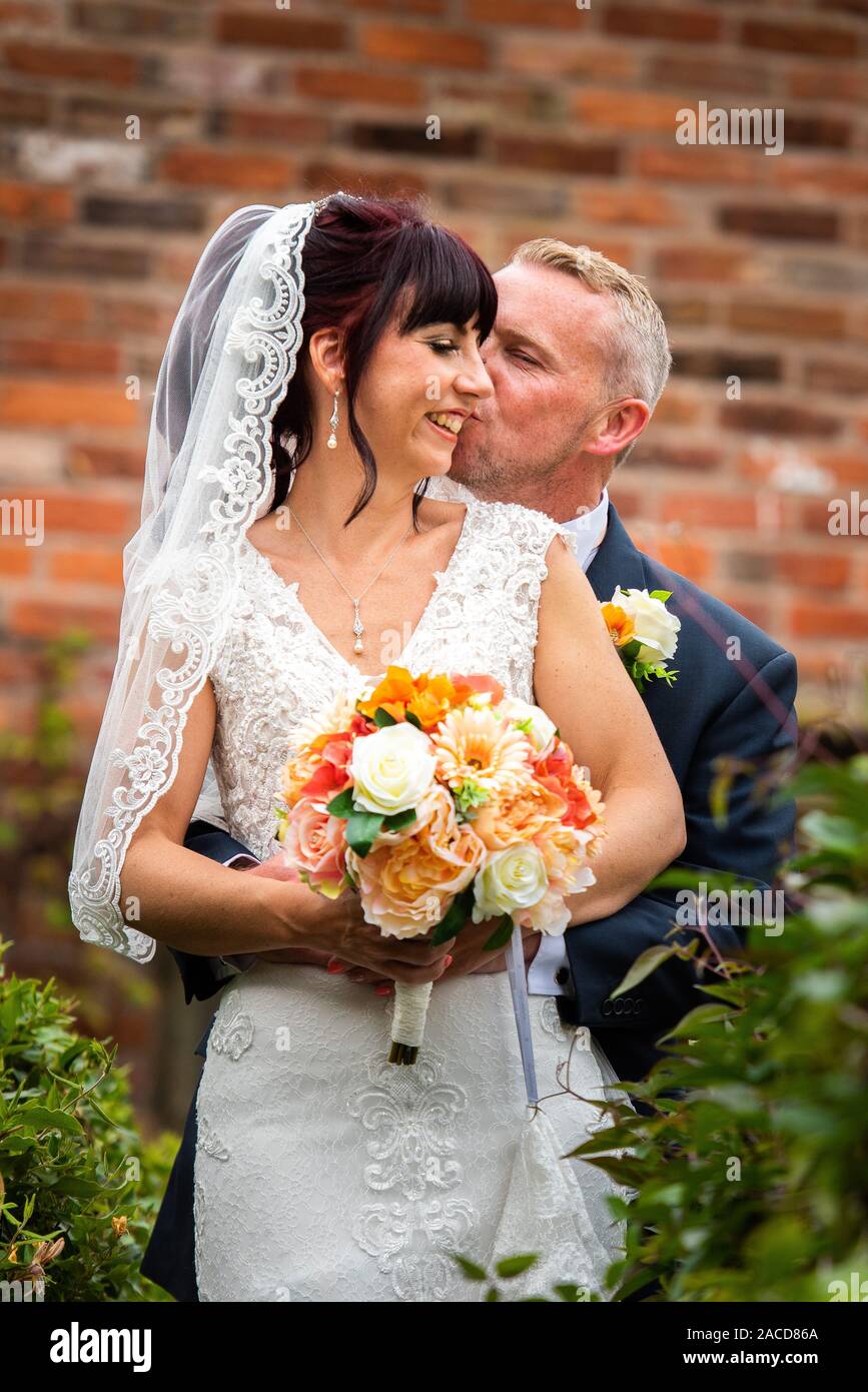 Bride and Groom pose for their after ceremony pictures in the gardens ...
