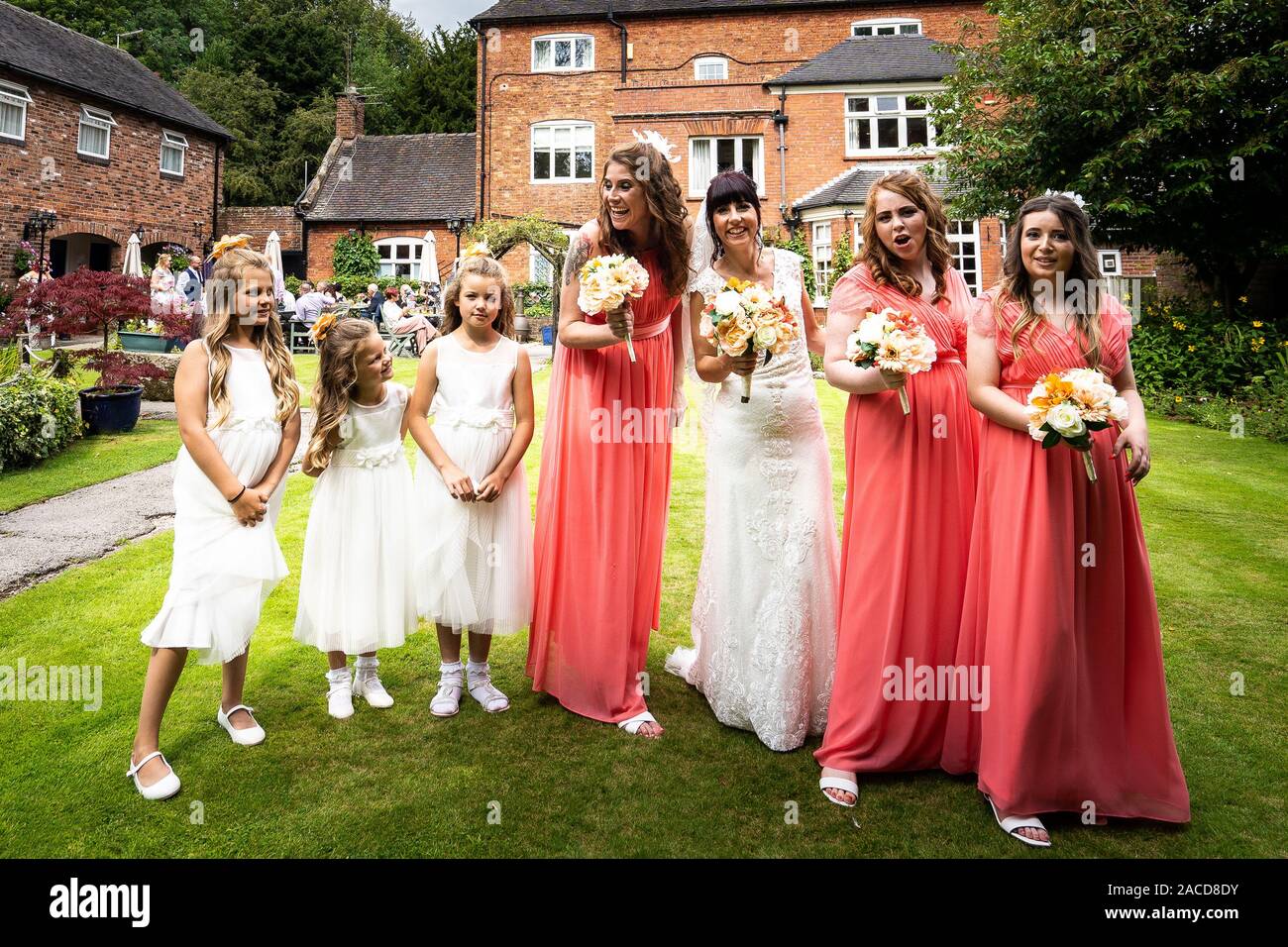 Bride, Groom and wedding guests pose for picture outside at the Manor ...
