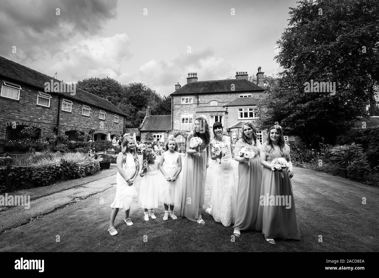 Bride, Groom and wedding guests pose for picture outside at the Manor ...