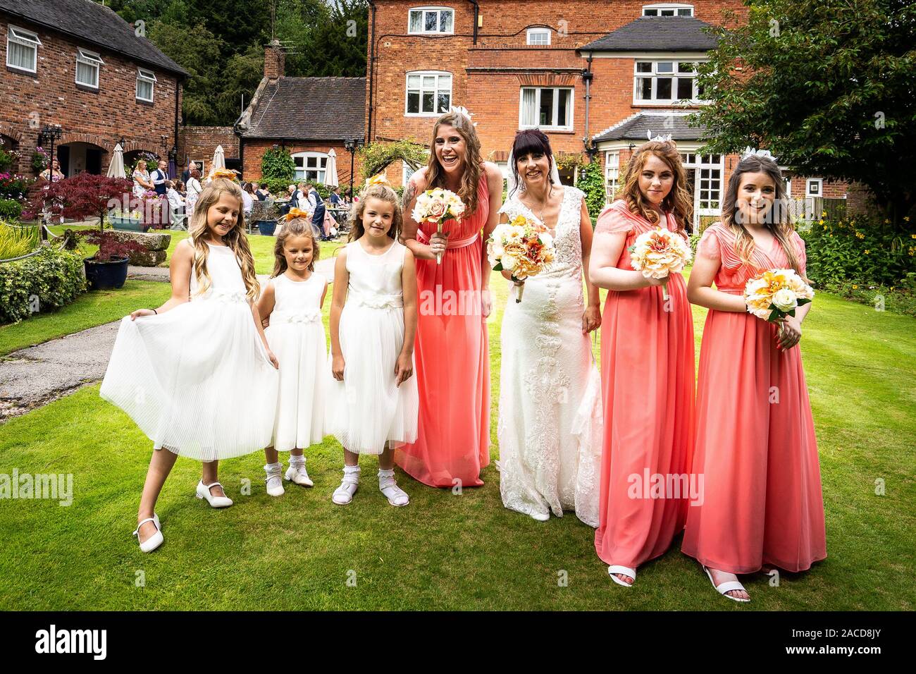 Bride, Groom and wedding guests pose for picture outside at the Manor ...