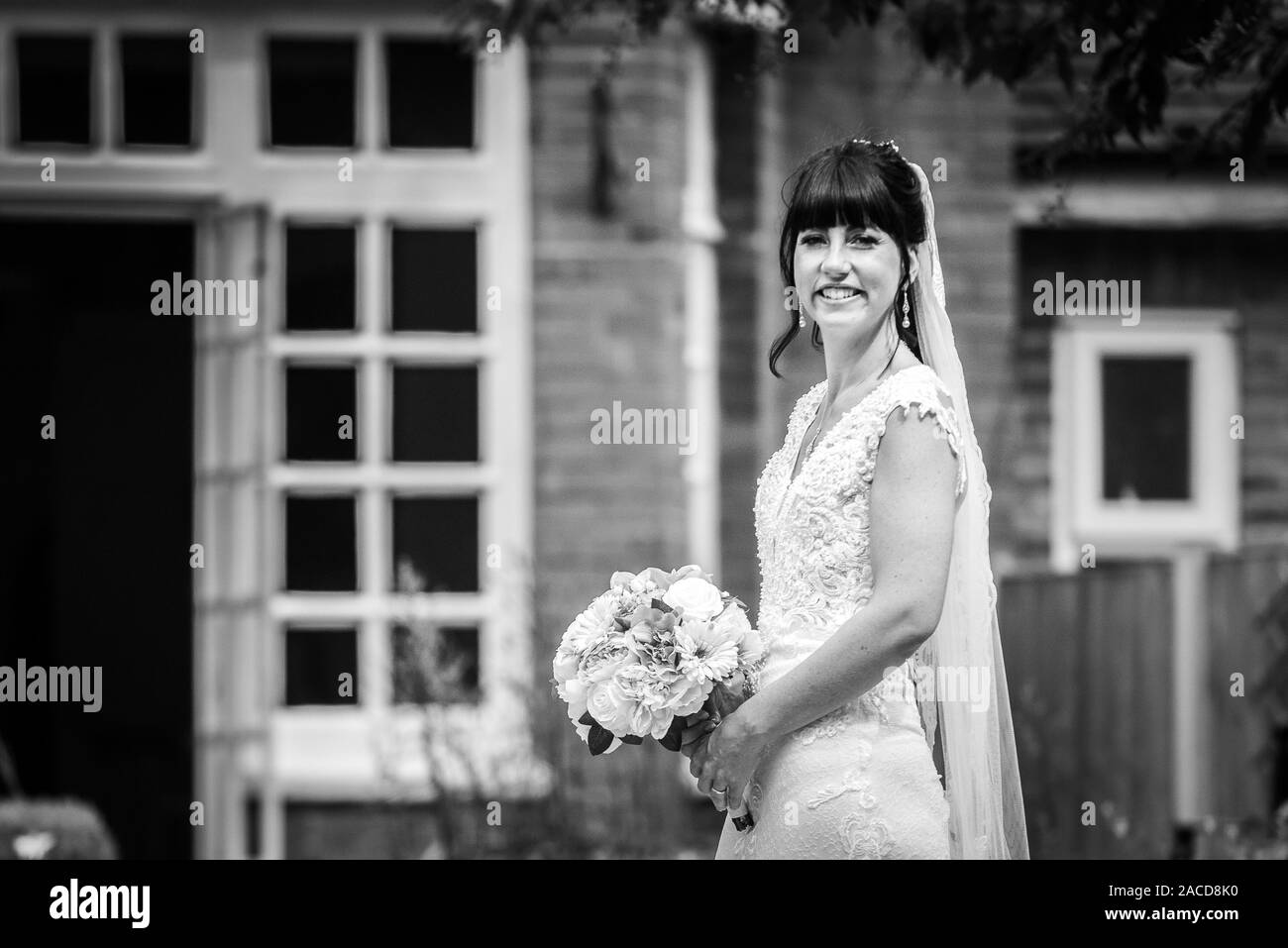 A bride poses for her after ceremony pictures in the gardens at the ...