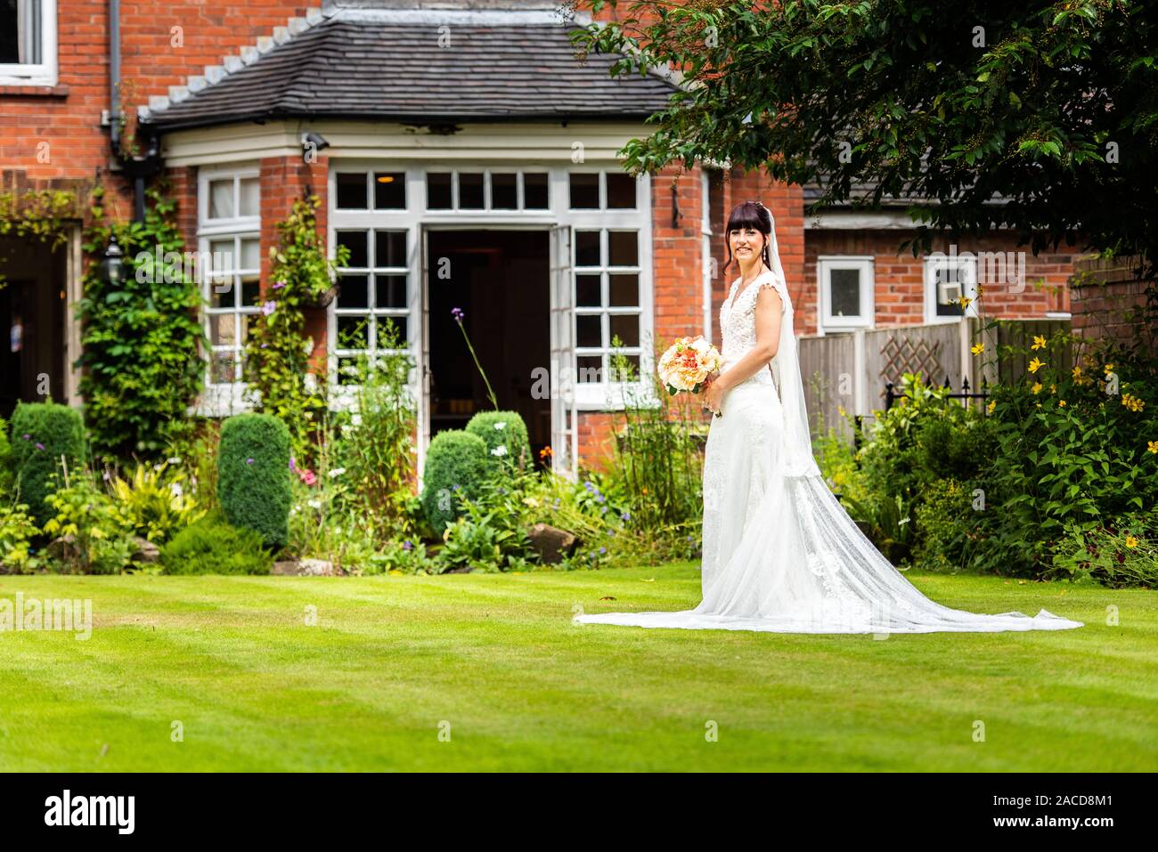 A bride poses for her after ceremony pictures in the gardens at the ...