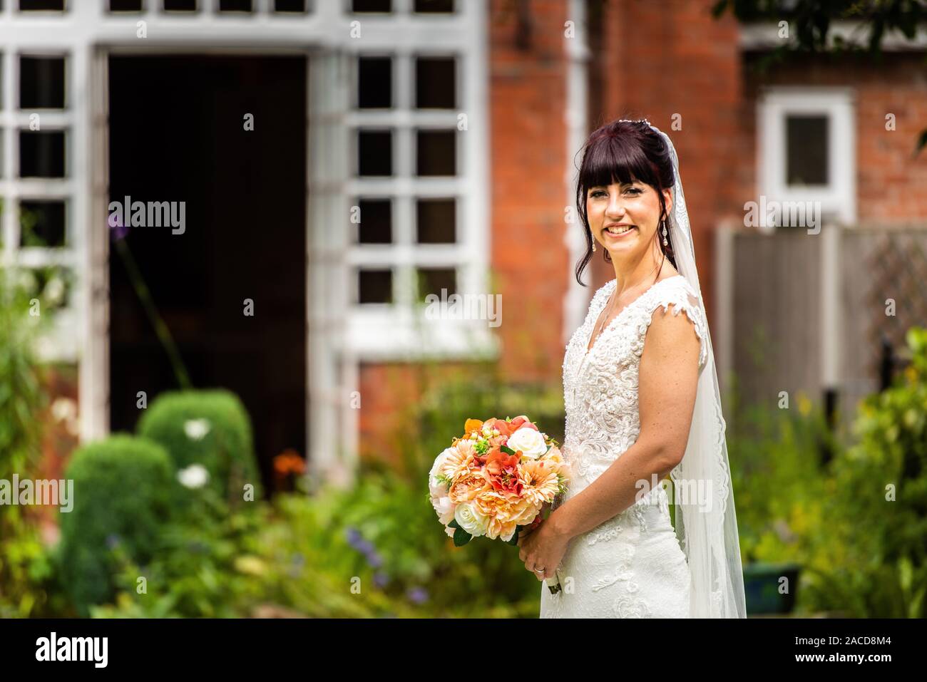 A bride poses for her after ceremony pictures in the gardens at the ...