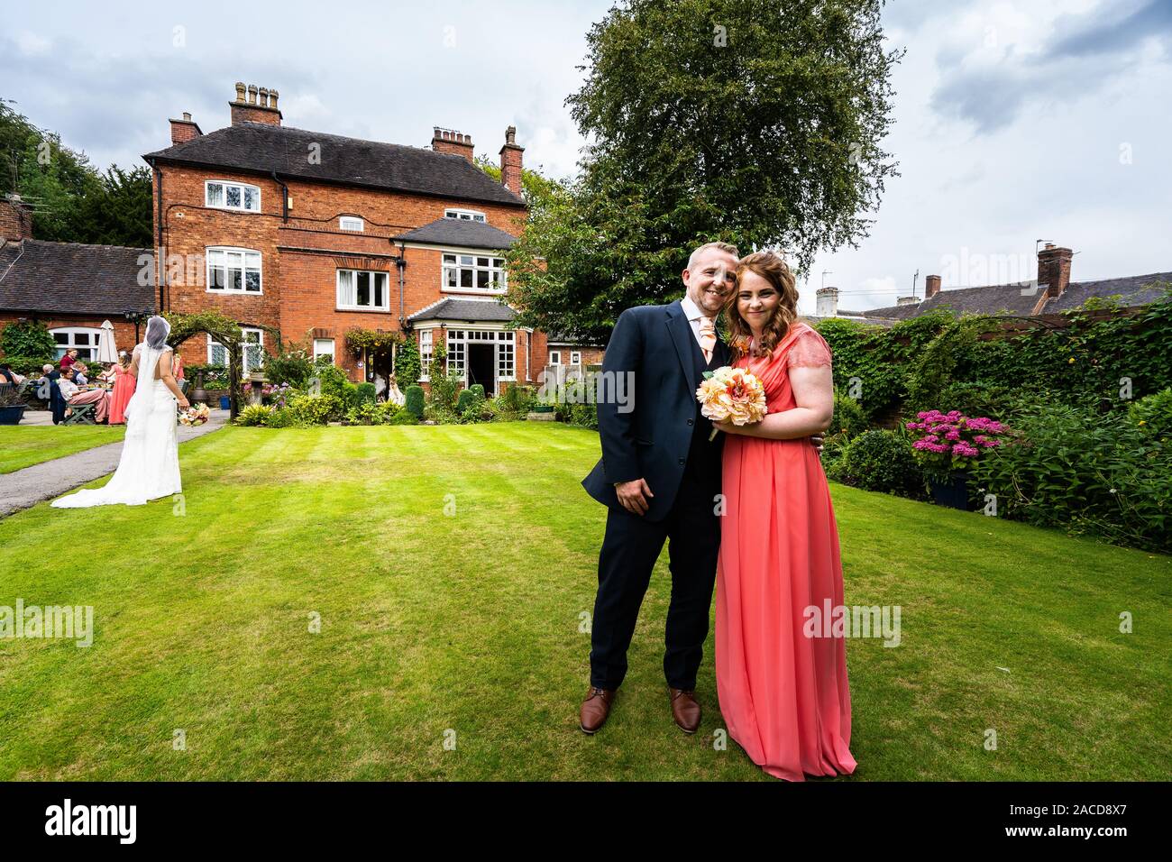 Bride, Groom and wedding guests pose for picture outside at the Manor ...