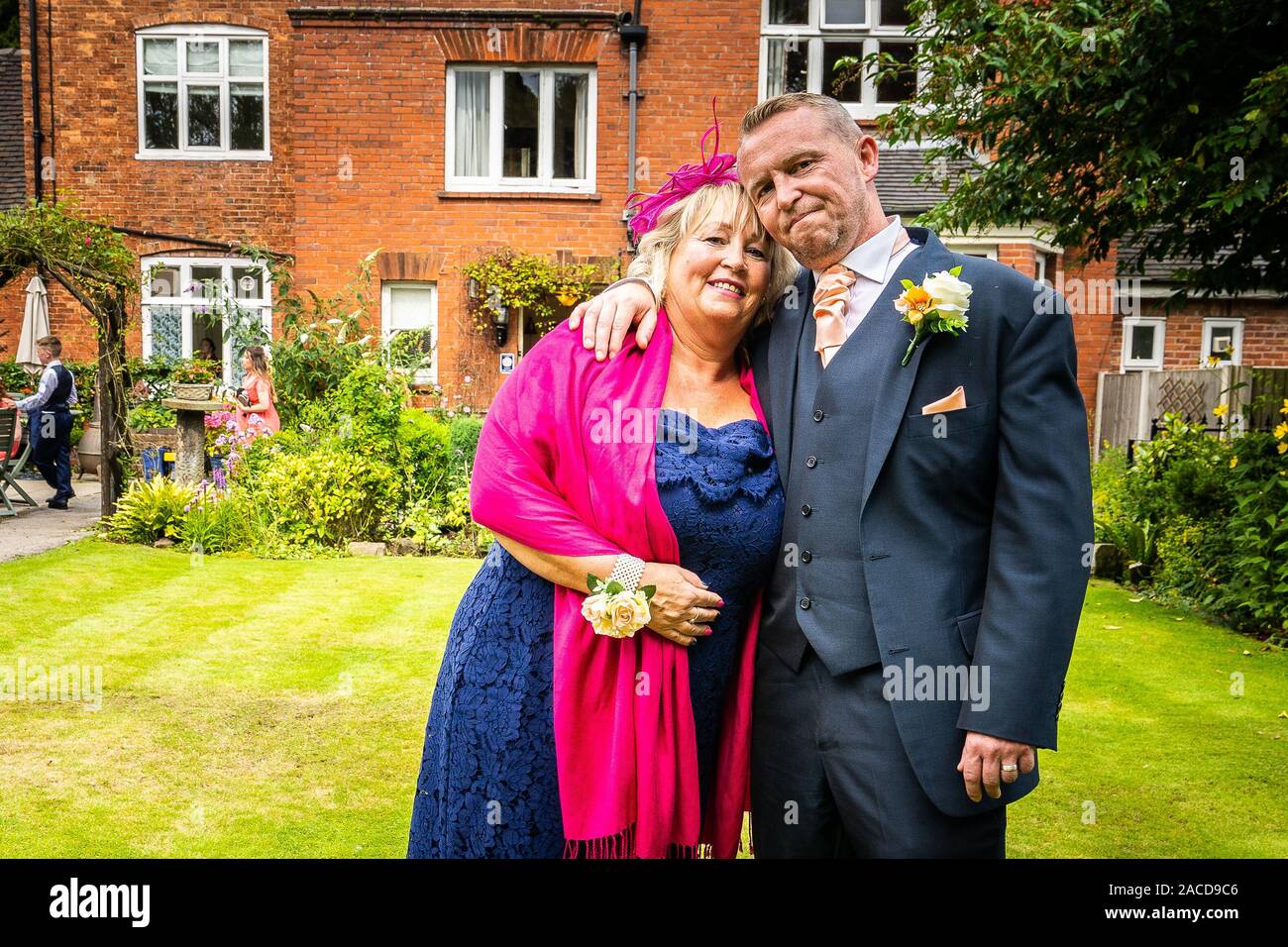 Bride, Groom and wedding guests pose for picture outside at the Manor ...