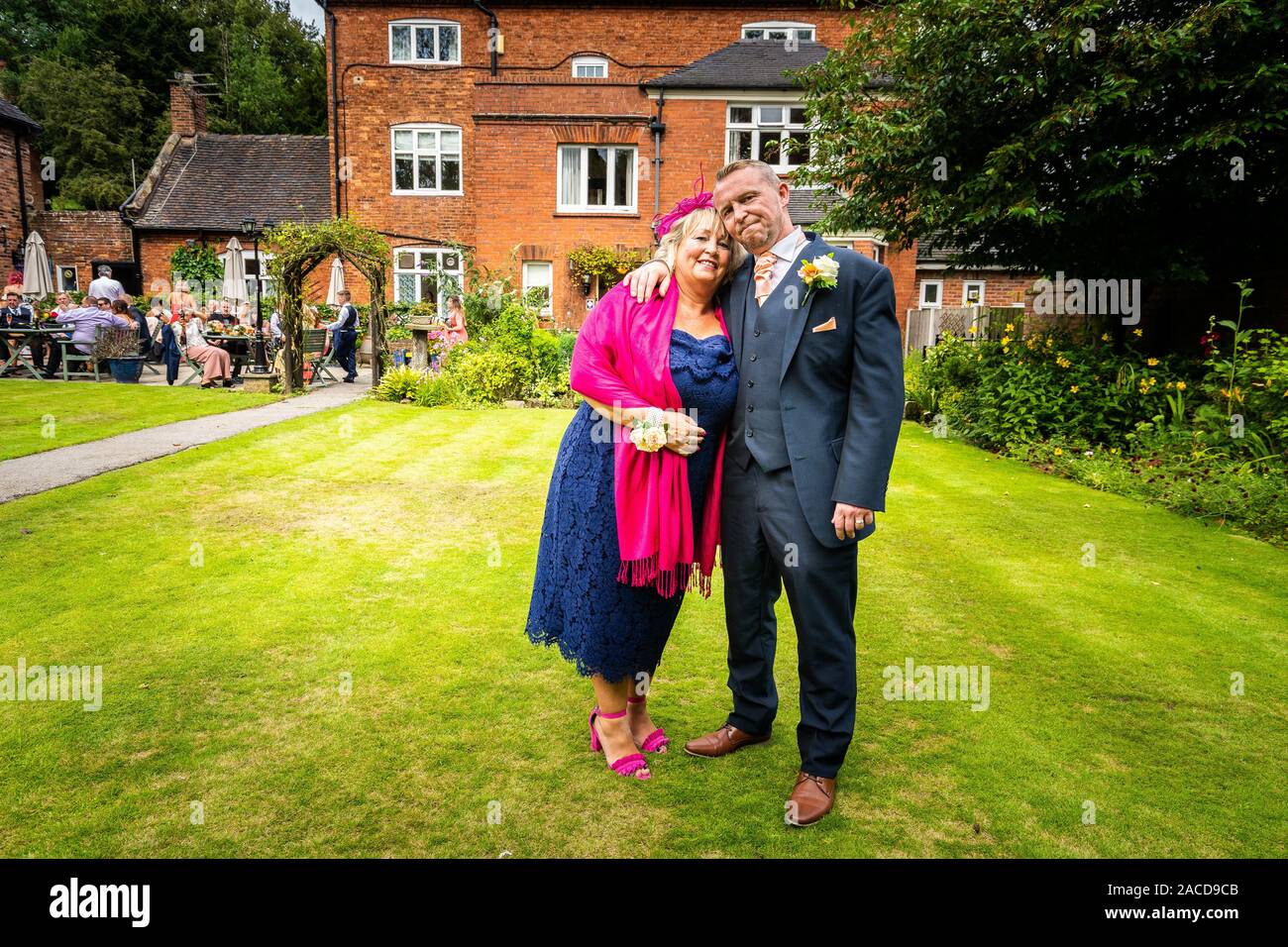 Bride, Groom and wedding guests pose for picture outside at the Manor ...