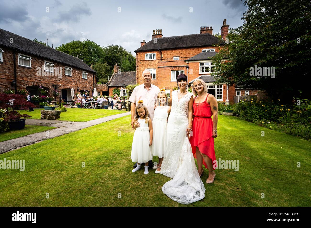 Bride, Groom and wedding guests pose for picture outside at the Manor ...