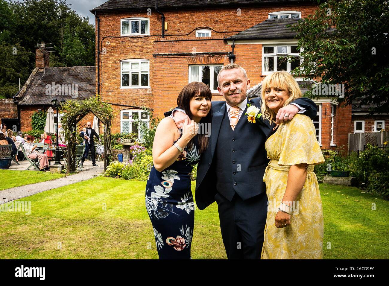Bride, Groom and wedding guests pose for picture outside at the Manor ...