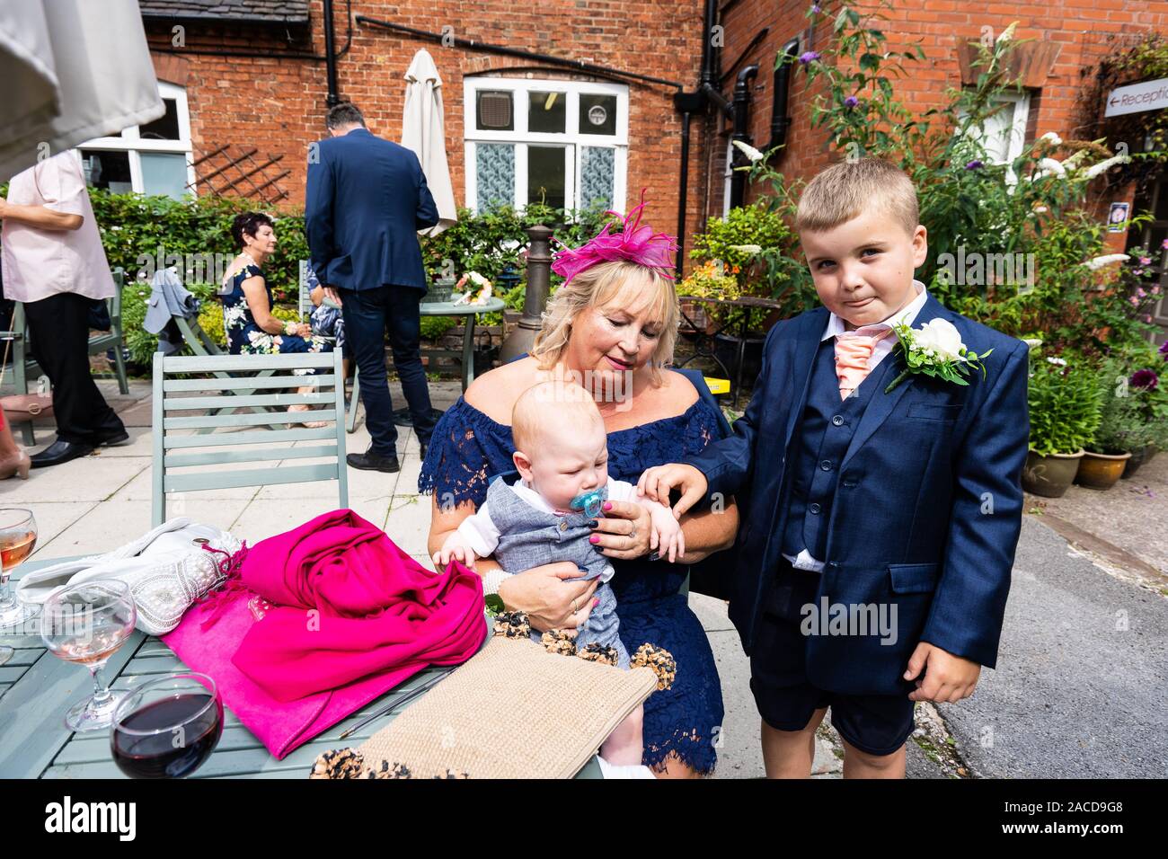 Bride, Groom and wedding guests pose for picture outside at the Manor ...