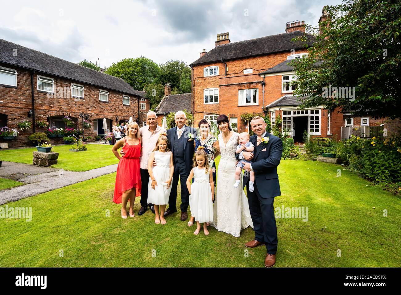 Bride, Groom and wedding guests pose for picture outside at the Manor ...