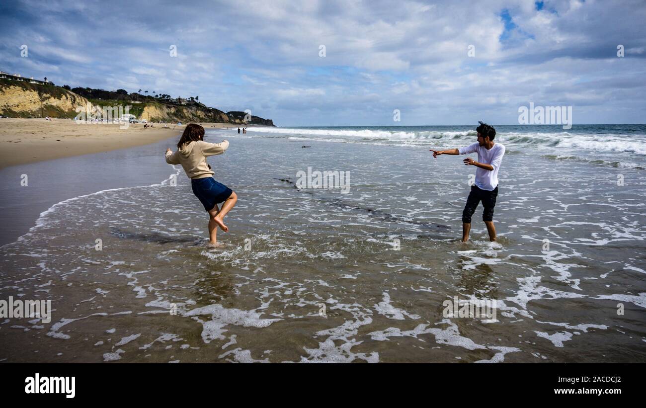 2 friends splashing each other at Malibu Beach in California, USA Stock ...