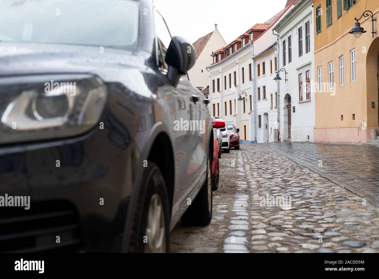 Scenic picture of a street in Sibiu medieval center, cars parked along ...