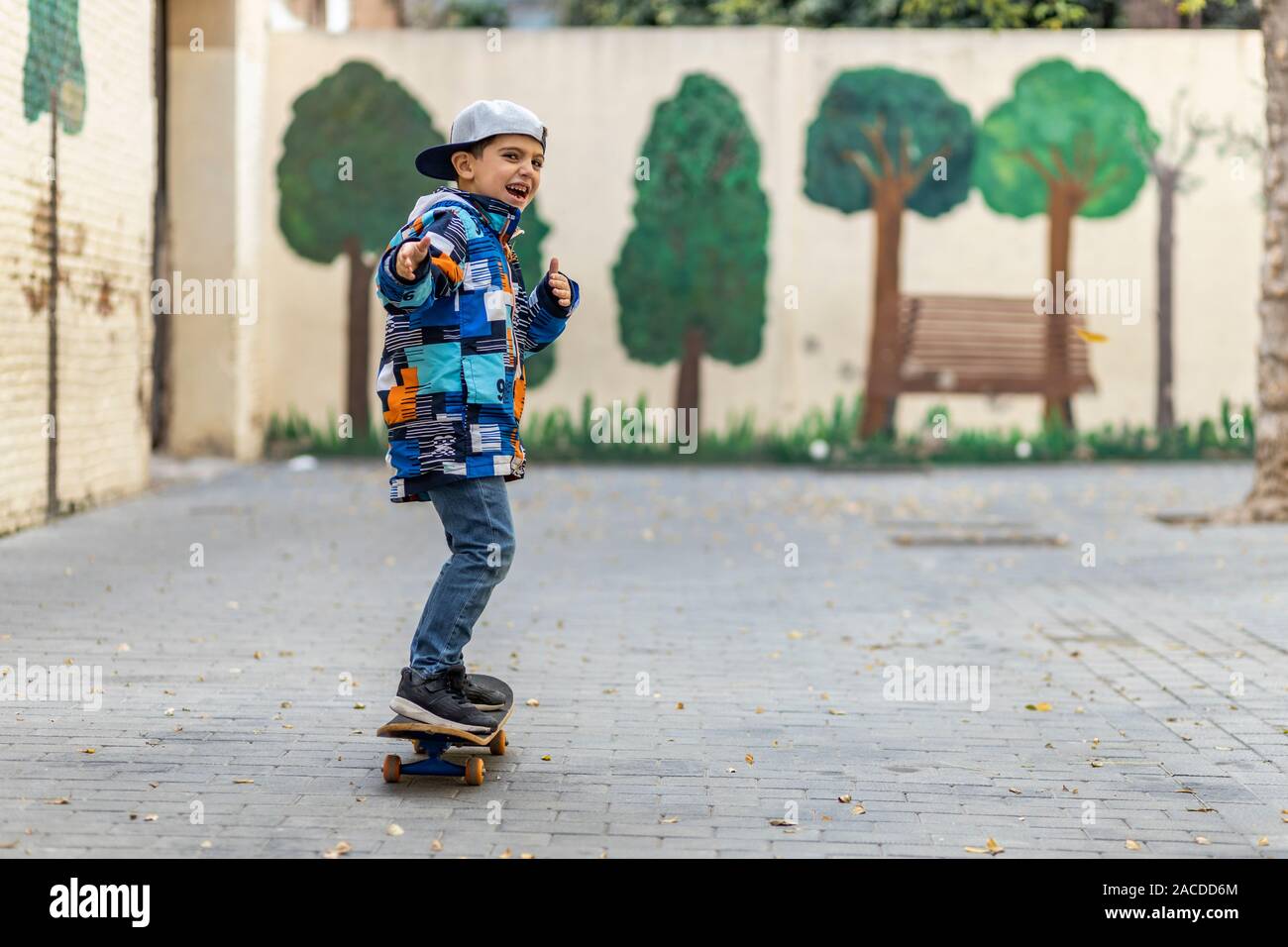 Euphoric little kid riding on his skateboard Stock Photo - Alamy