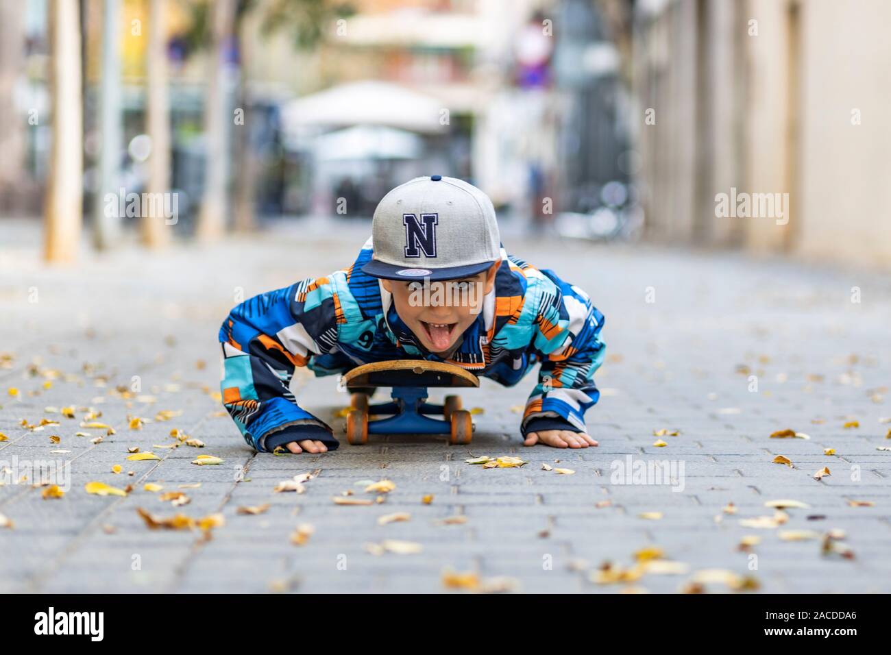 Cute little kid stretched on a skateboard Stock Photo - Alamy