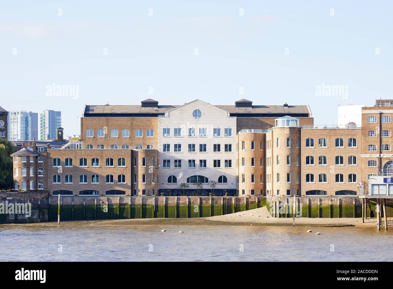 Front elevation across Thames at low tide. Devon House, London, United Kingdom. Architect: Stiff ...