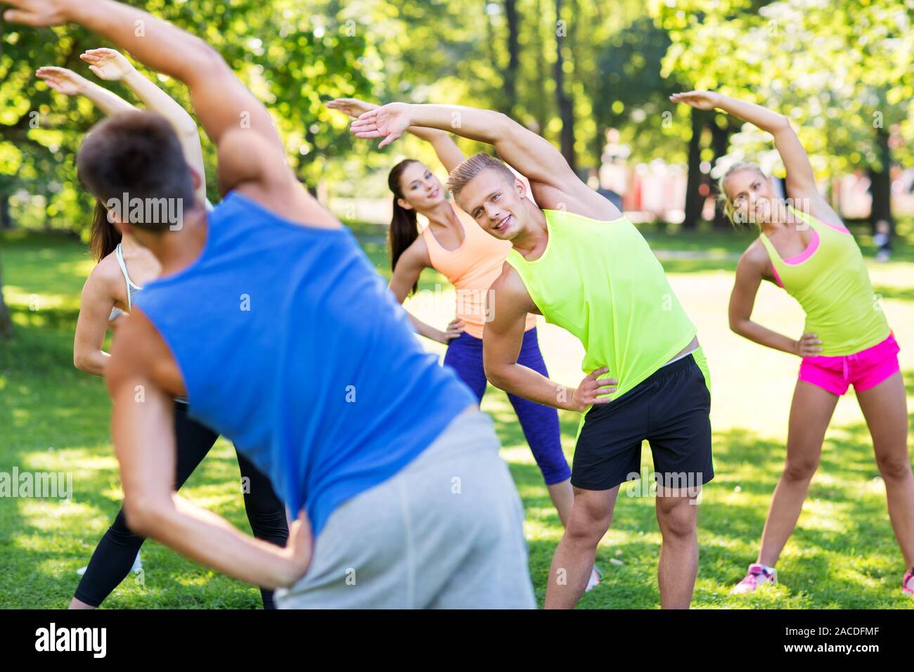 group of happy people exercising at summer park Stock Photo - Alamy