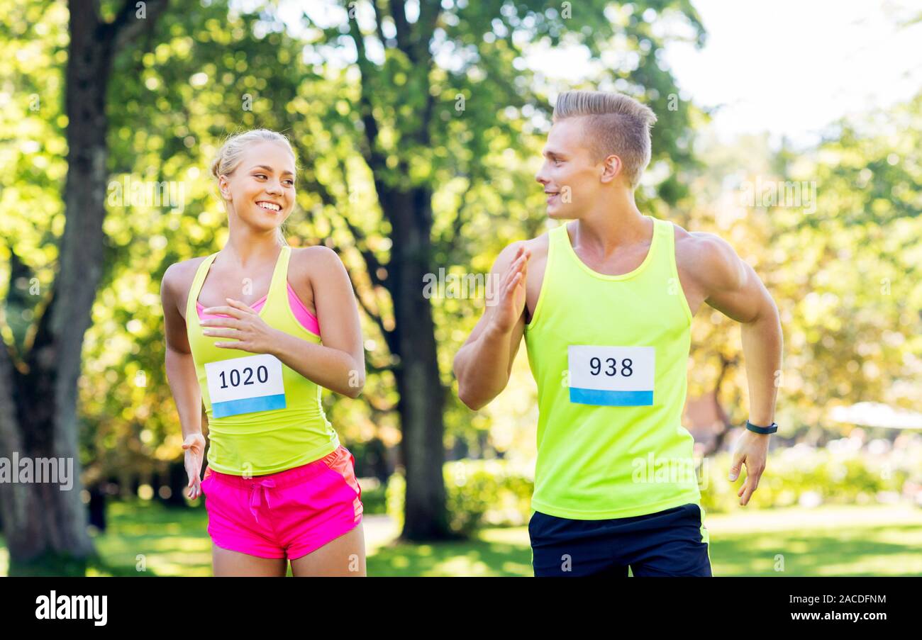 happy couple of sportsmen racing wit badge numbers Stock Photo - Alamy