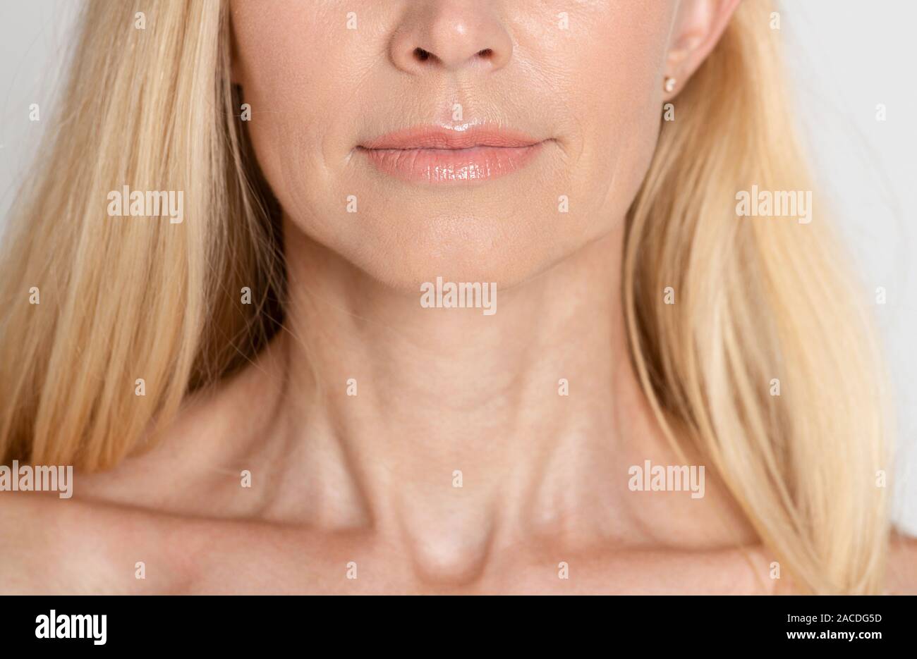 Beautiful mature woman with wrinkled neck, grey background Stock Photo ...