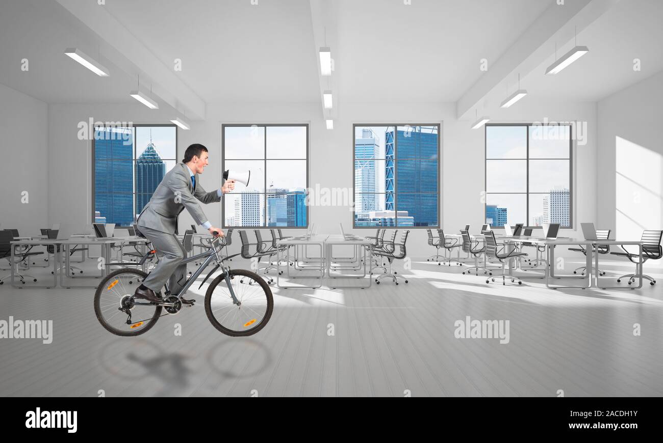 Manager riding bicycle at conference hall Stock Photo - Alamy
