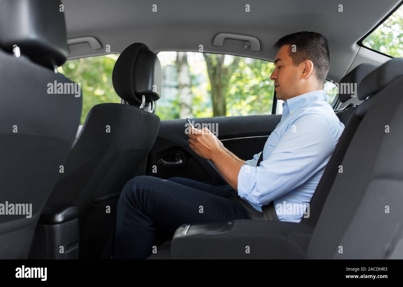 passenger or businessman using smartphone in car Stock Photo - Alamy