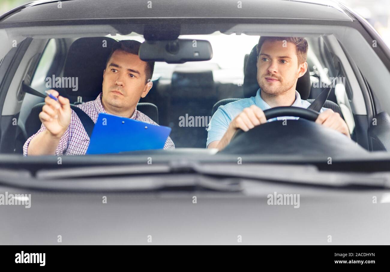 car driving school instructor and young driver Stock Photo - Alamy