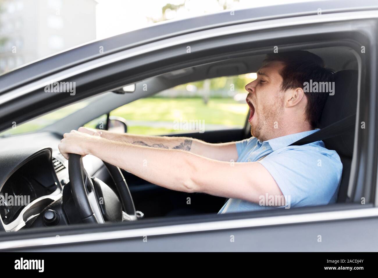 tired sleepy man or driver driving car and yawning Stock Photo - Alamy