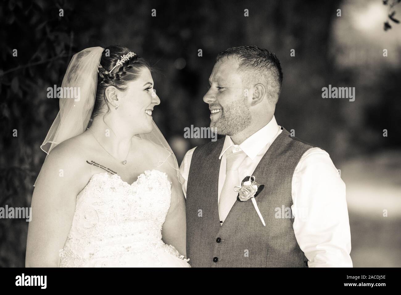 A bride and groom smiling, laughing together happy and in love on their ...