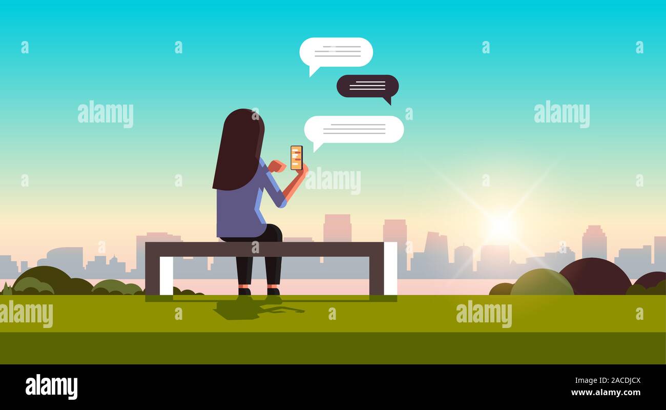 rear view woman sitting on bench using chatting mobile app on ...
