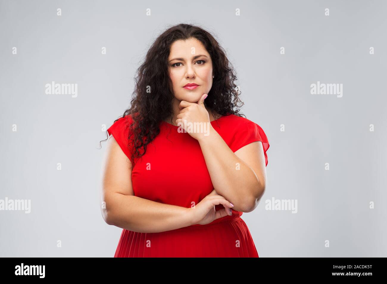 serious woman in red dress thinking Stock Photo - Alamy