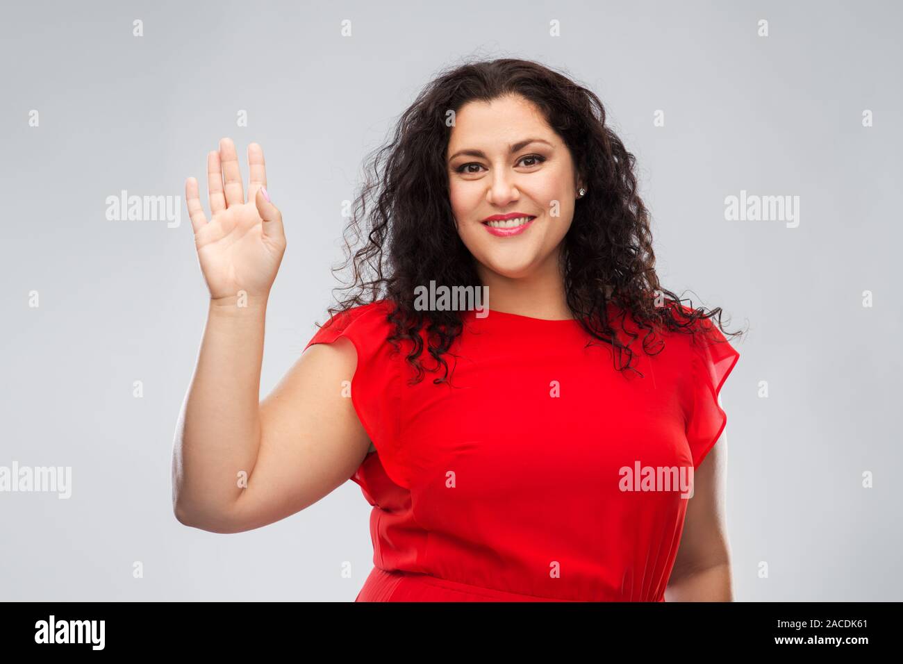 happy woman in red dress waving hand Stock Photo - Alamy
