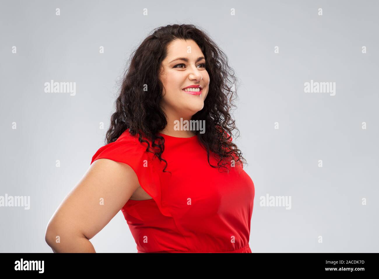 happy woman in red dress over grey background Stock Photo - Alamy