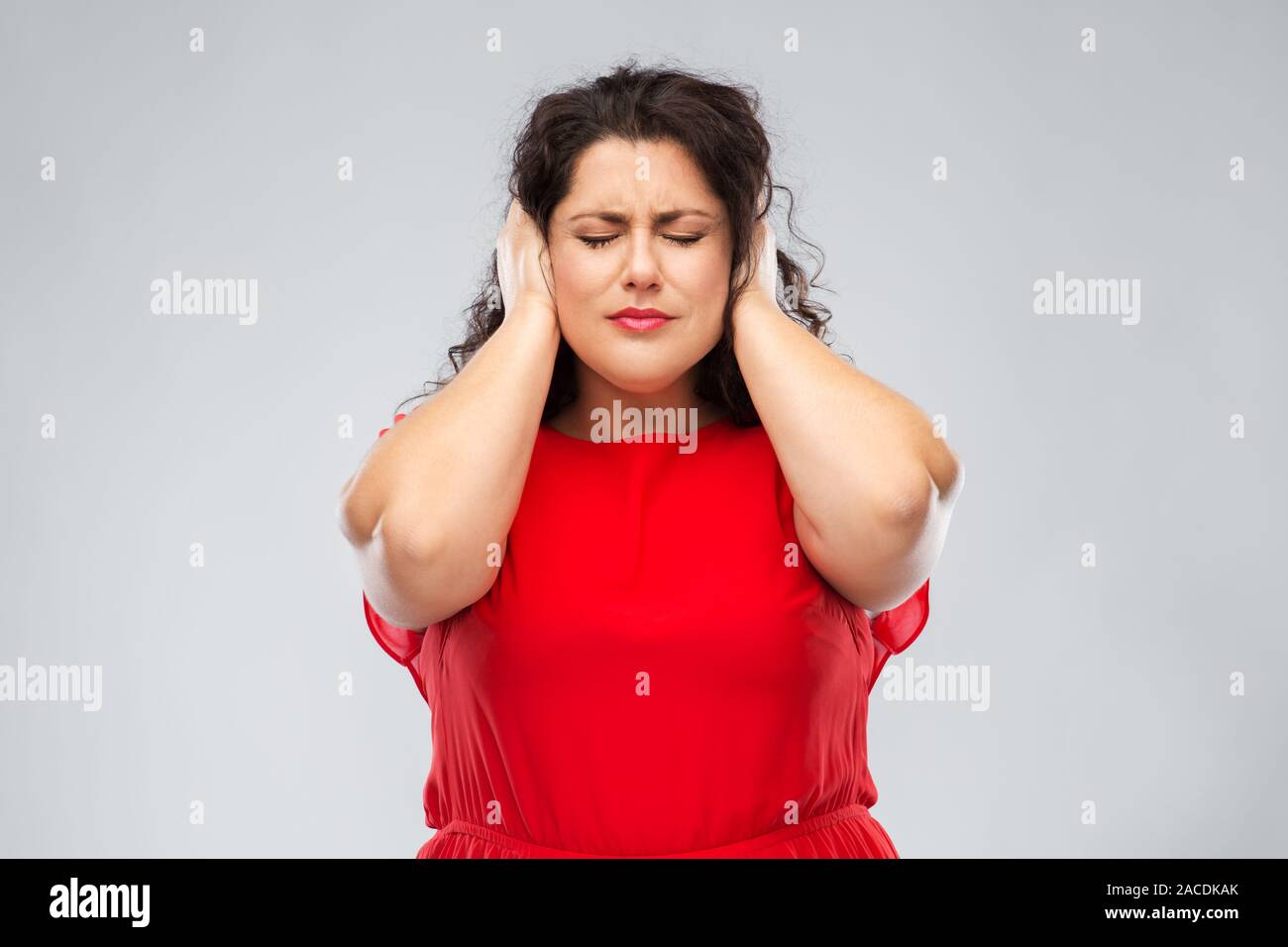 woman in red dress closing her ears by hands Stock Photo - Alamy