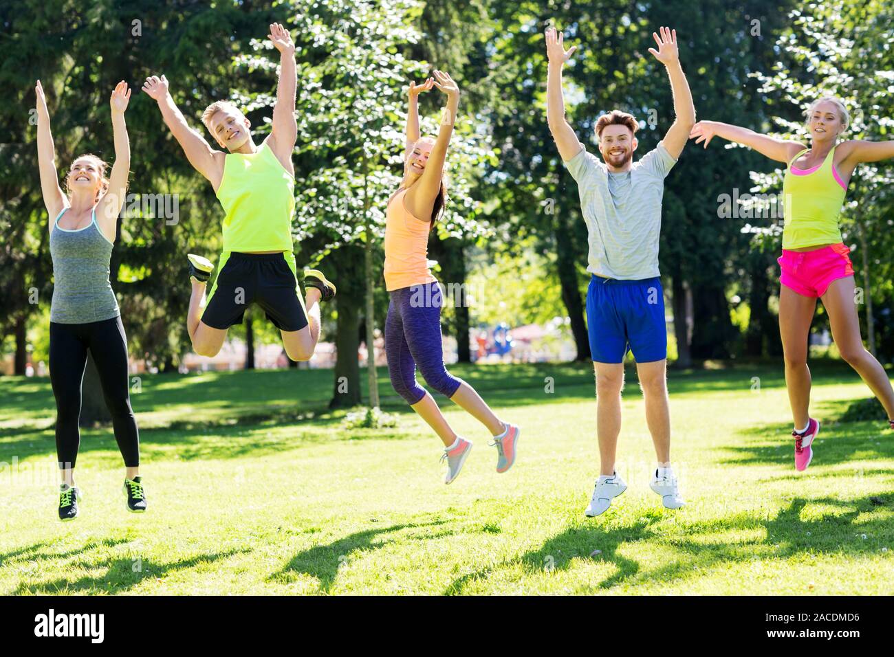 group of happy friends jumping high at park Stock Photo - Alamy