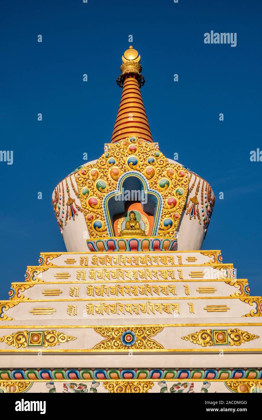 Upper part of a beautifully painted white Buddhist Stupa with a small ...