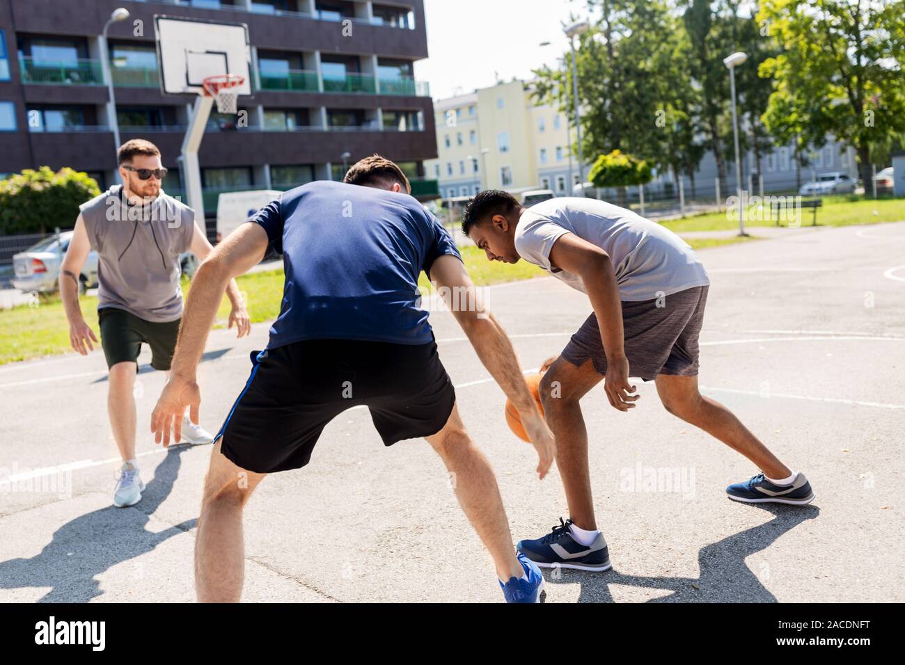 group of male friends playing street basketball Stock Photo - Alamy