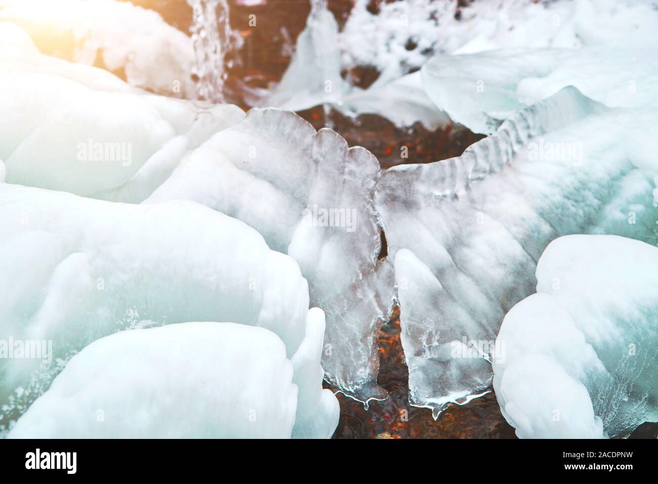 Frozen source covered with clear blue ice with bright sunlight Stock ...