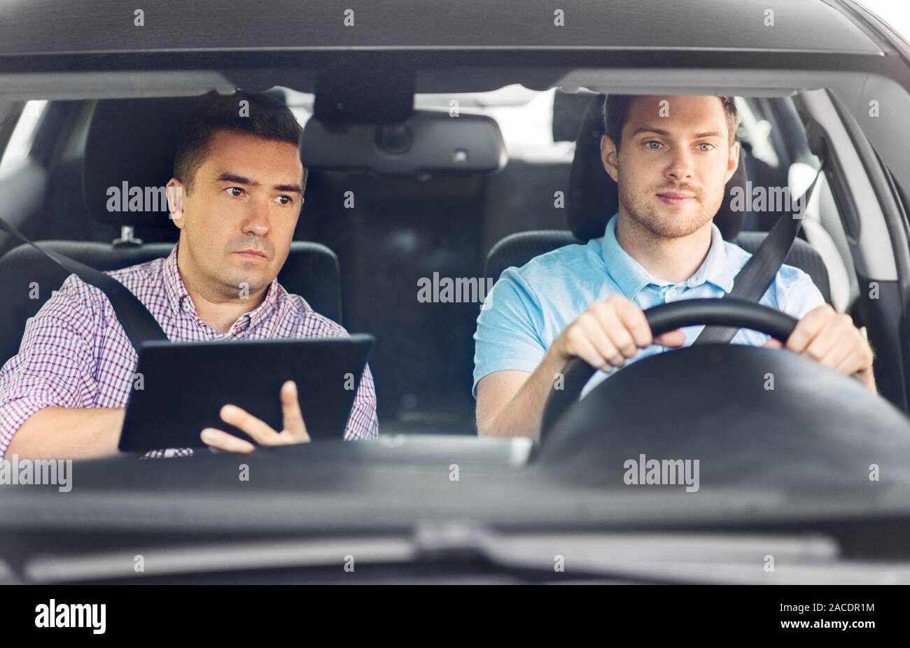 car driving school instructor and young driver Stock Photo - Alamy