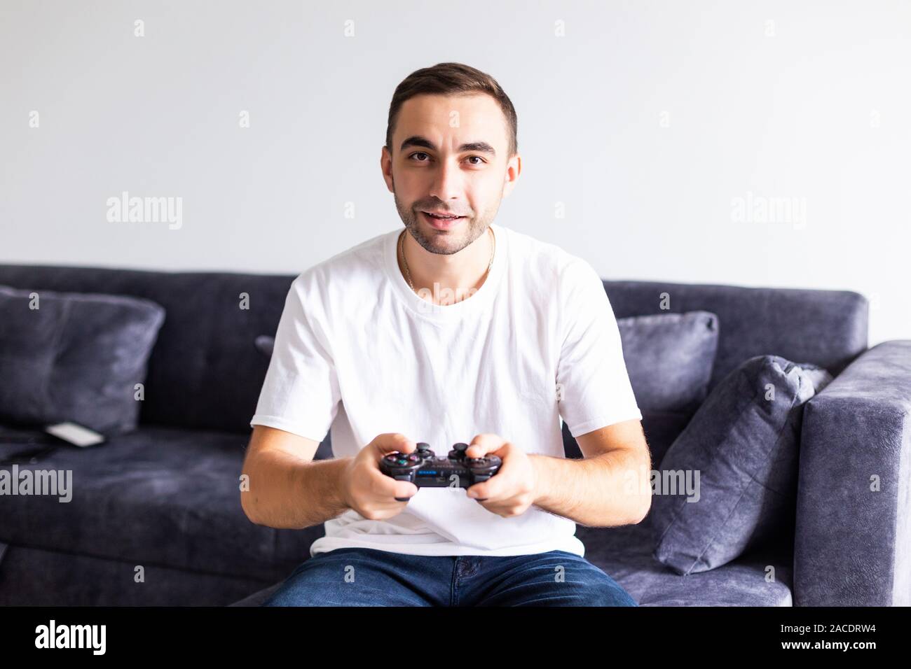 Young man laughing and playing video games on weekend Stock Photo - Alamy