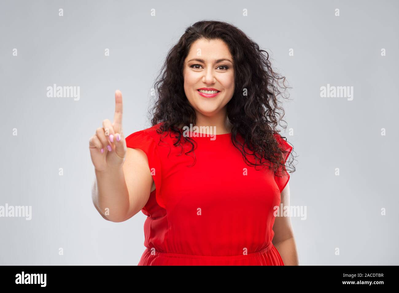 happy woman in red dress showing one finger Stock Photo - Alamy