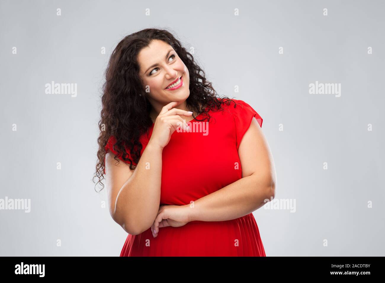 happy smiling woman in red dress thinking Stock Photo - Alamy