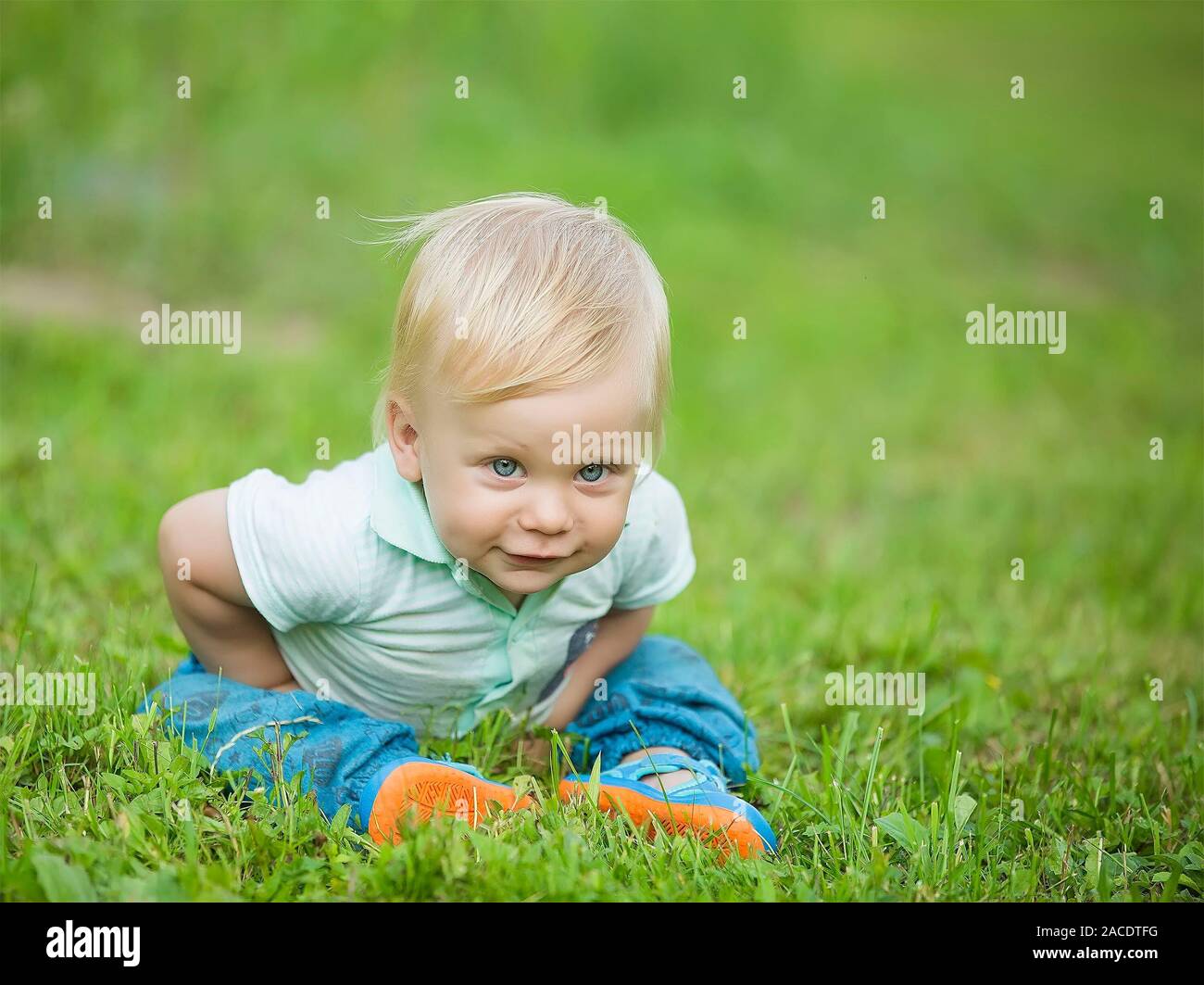 cute toddler smiling in the green grass Stock Photo - Alamy